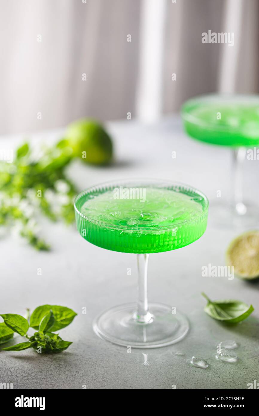 Summer green cocktail with lime, basil and ice in a crystal glass Stock ...