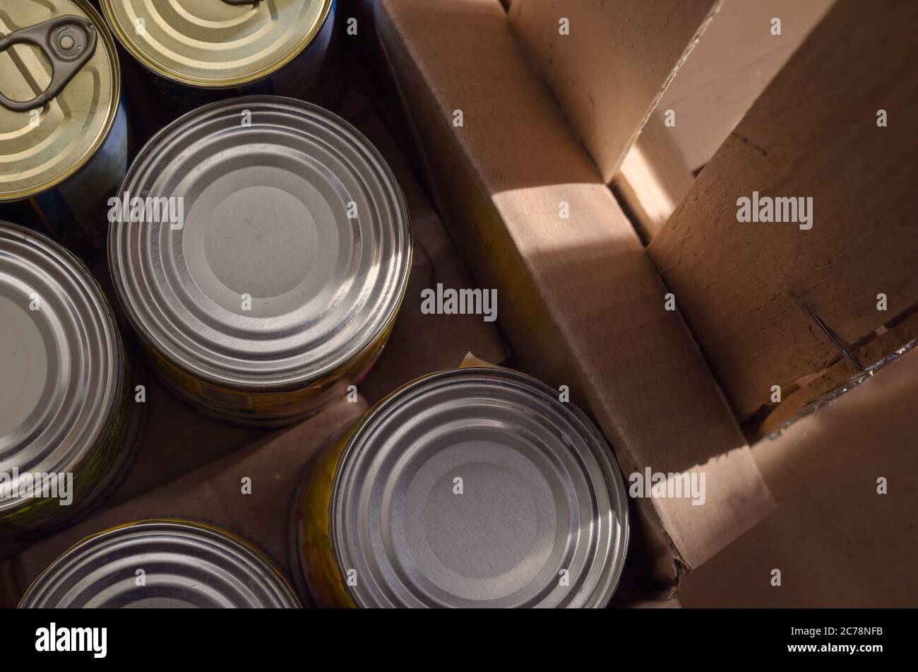 Tin cans in a cardboard box. Variety of canned food in full tin cans ...