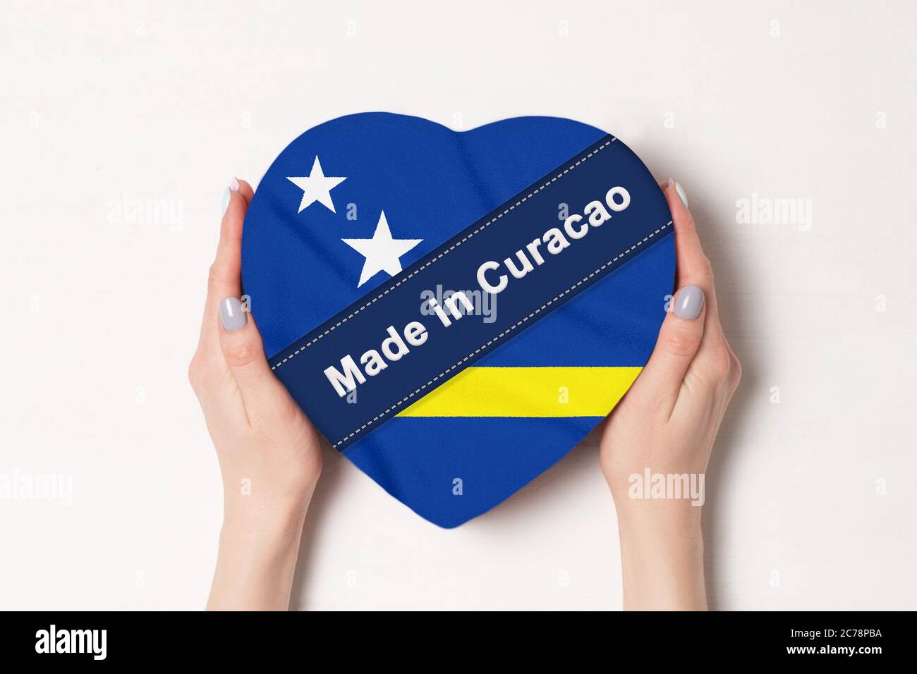Inscription Made in Curacao the flag of Curacao. Female hands holding a ...
