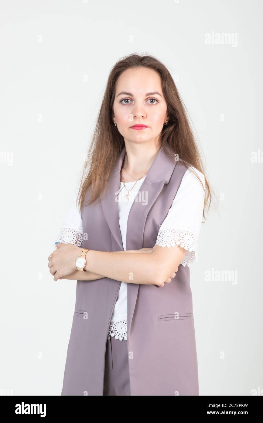 beautiful young woman in business strict clothes poses against a white ...