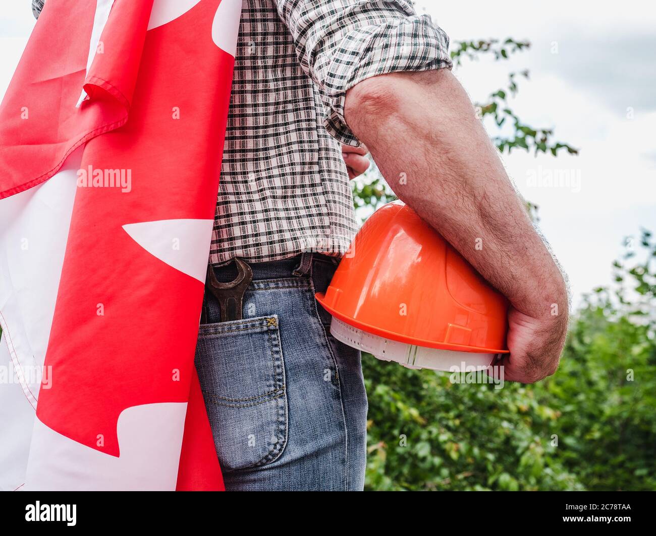 Handsome man with tools, holding a Canadian Flag Stock Photo - Alamy