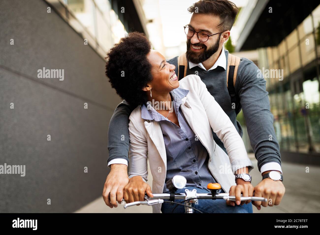 Cheerful people going for a bike ride. Happy couple having fun in the ...