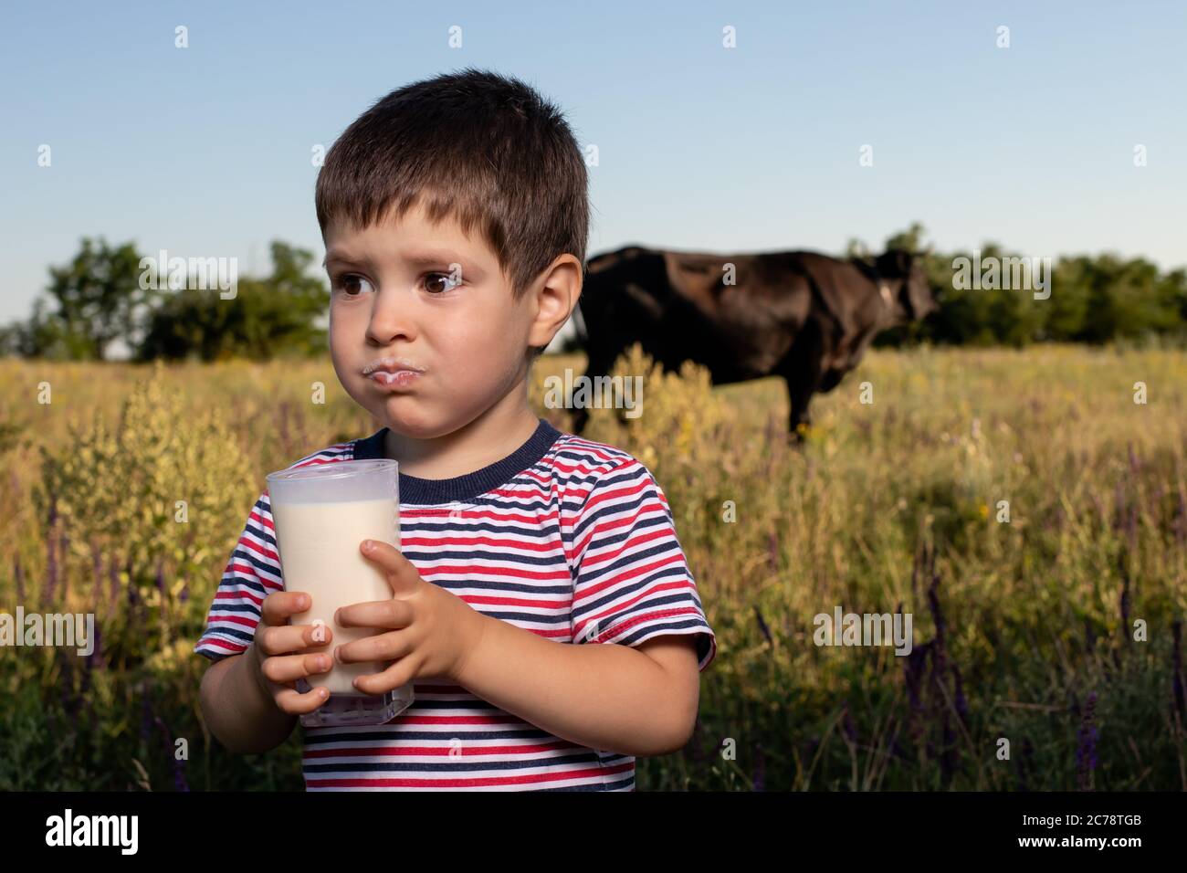 A small child boy 3 years old for the first time tastes cow's milk ...
