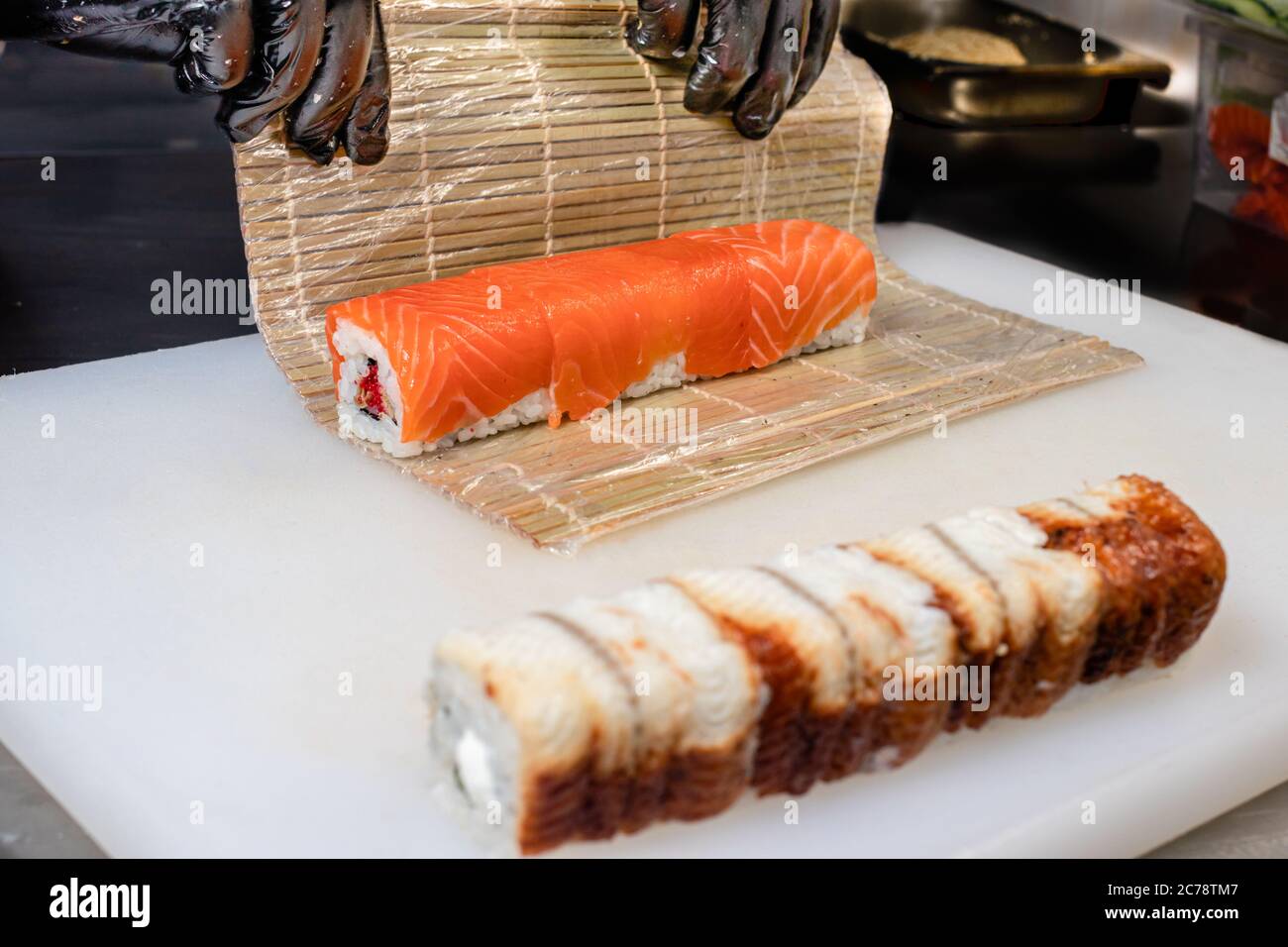 The process of cooking sushi, wrapping the roll in a nori leaf ...