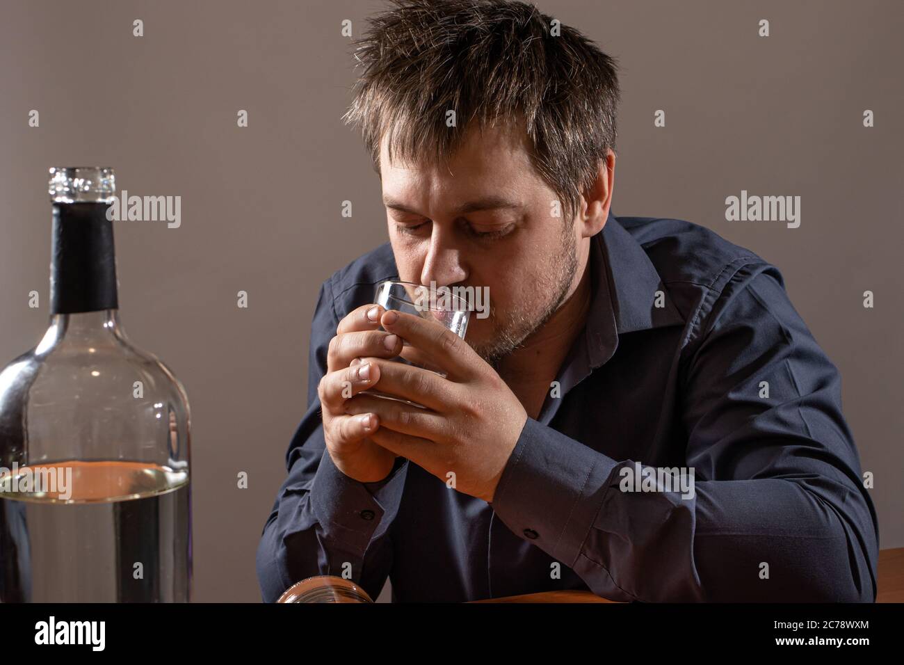 A man in alcoholic intoxication holds a glass of alcohol. Alcoholism ...