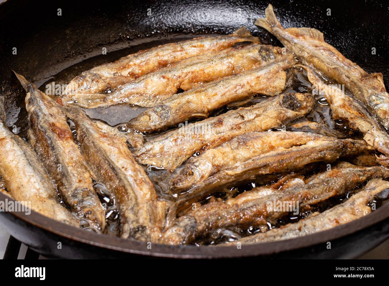 Capelin fish is fried in a pan in vegetable oil. Cooking, seafood Stock ...