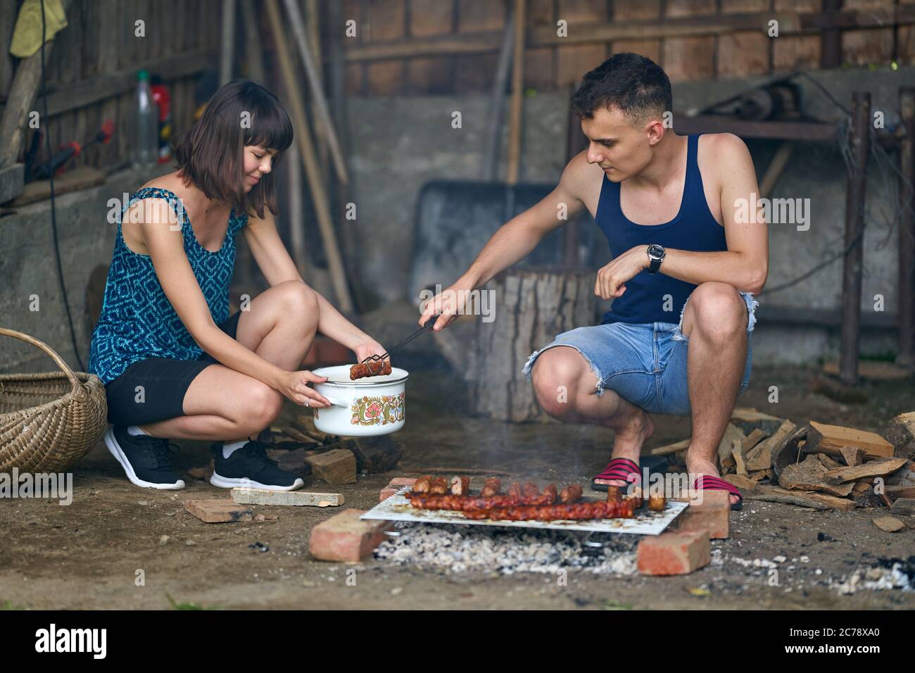 Happy young couple making a barbecue in the countryside Stock Photo - Alamy