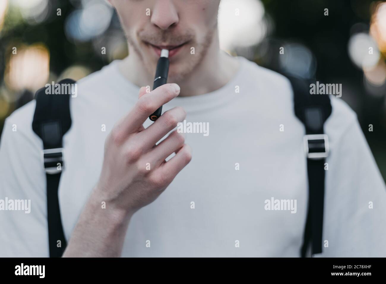 A young man in nature holds IQOS in his hand Stock Photo - Alamy