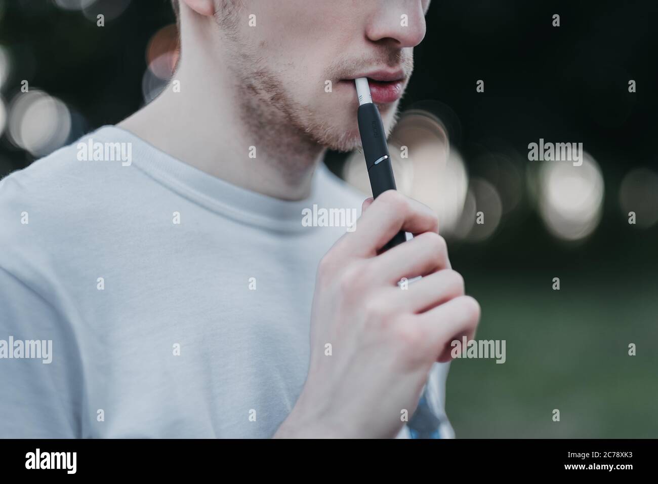 A young man in nature smoking IQOS Stock Photo - Alamy