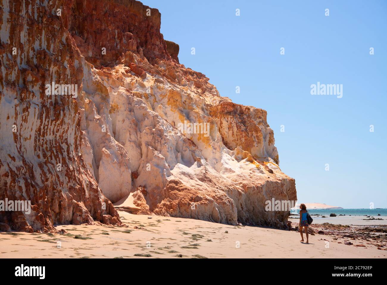 Colored stones and sand on the beach, in the background cliffs with ...