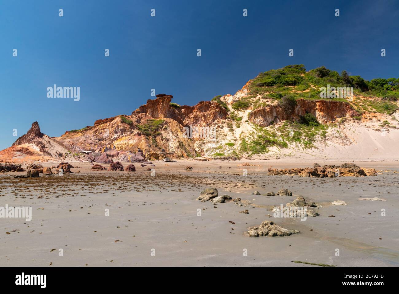 Colored stones and sand on the beach, in the background cliffs with ...
