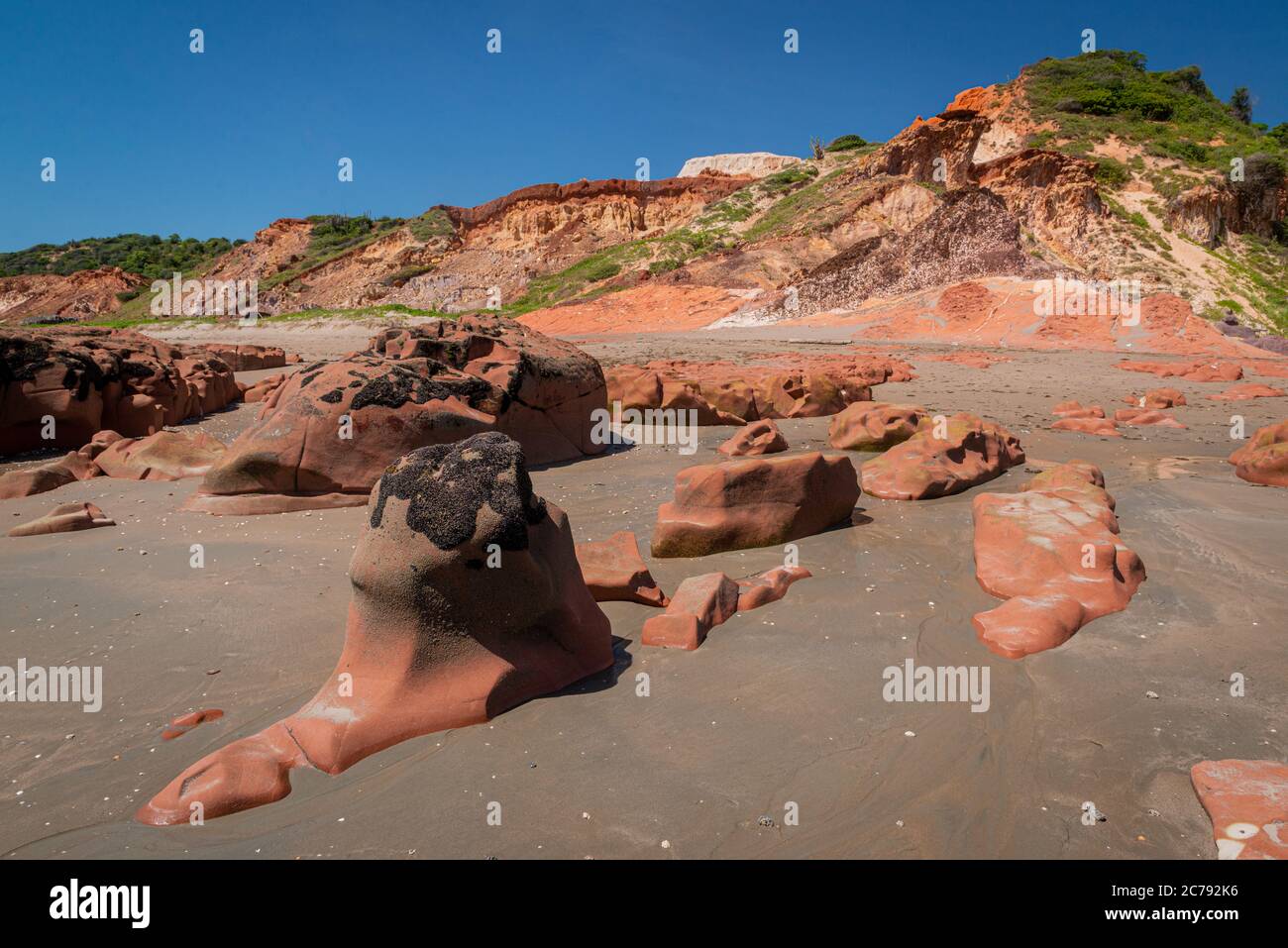 Colored stones and sand on the beach, in the background cliffs with ...