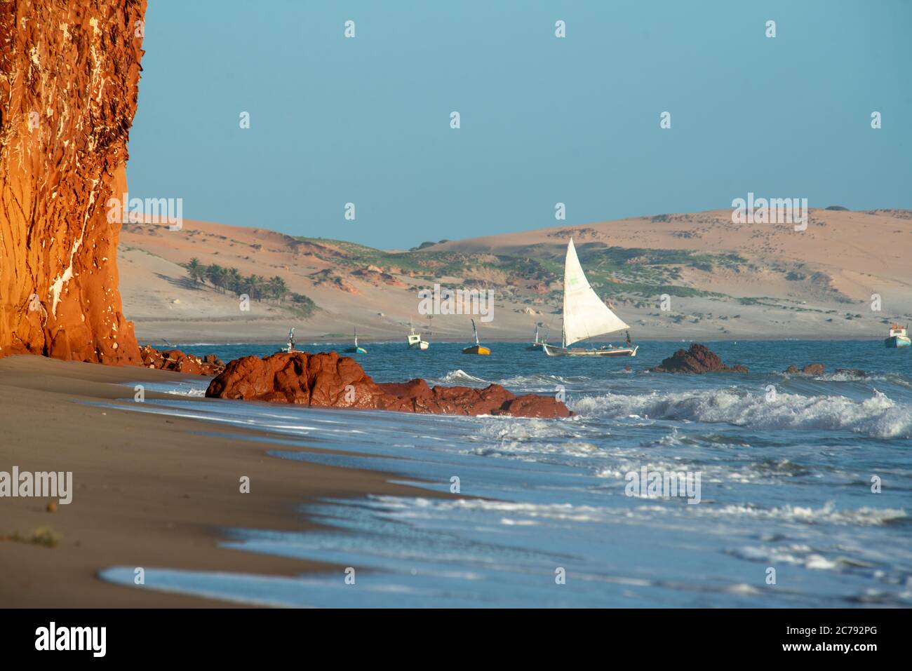 Colorful cliffs, dunes and small sailing boat early morning on the ...