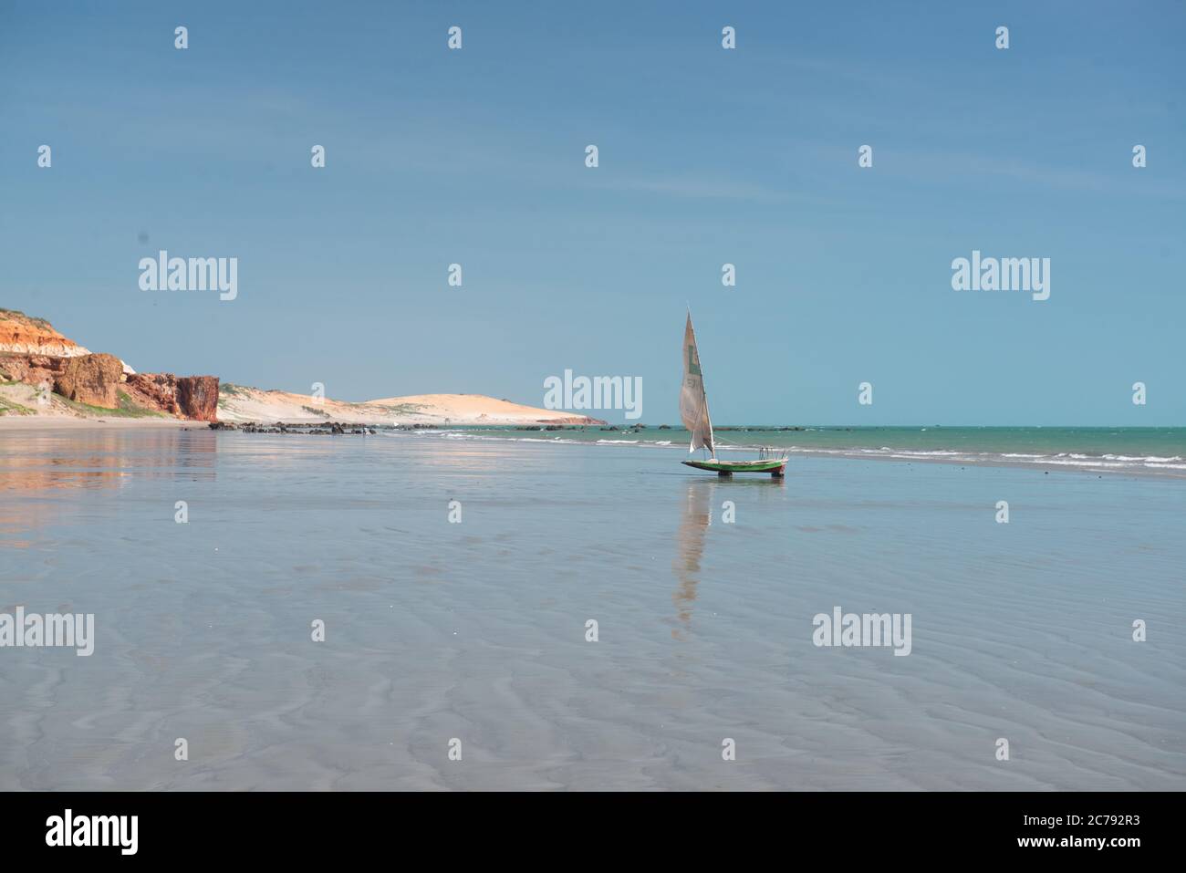Colorful cliffs, dunes and small sailing boat early morning on the ...