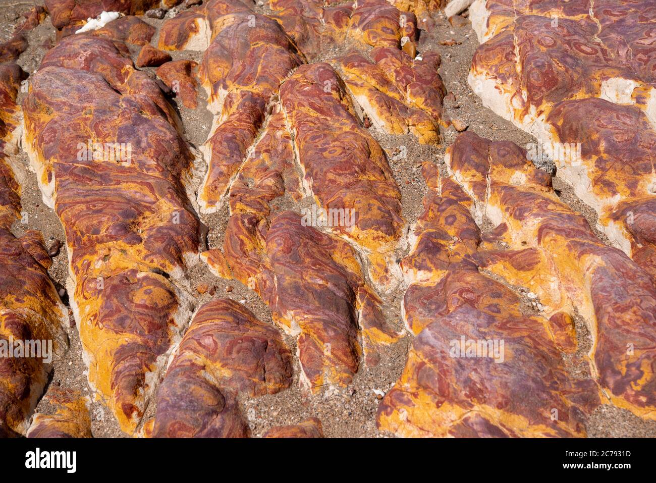 Colorful sand and sedimentary rocks, creating abstract patterns on the ...