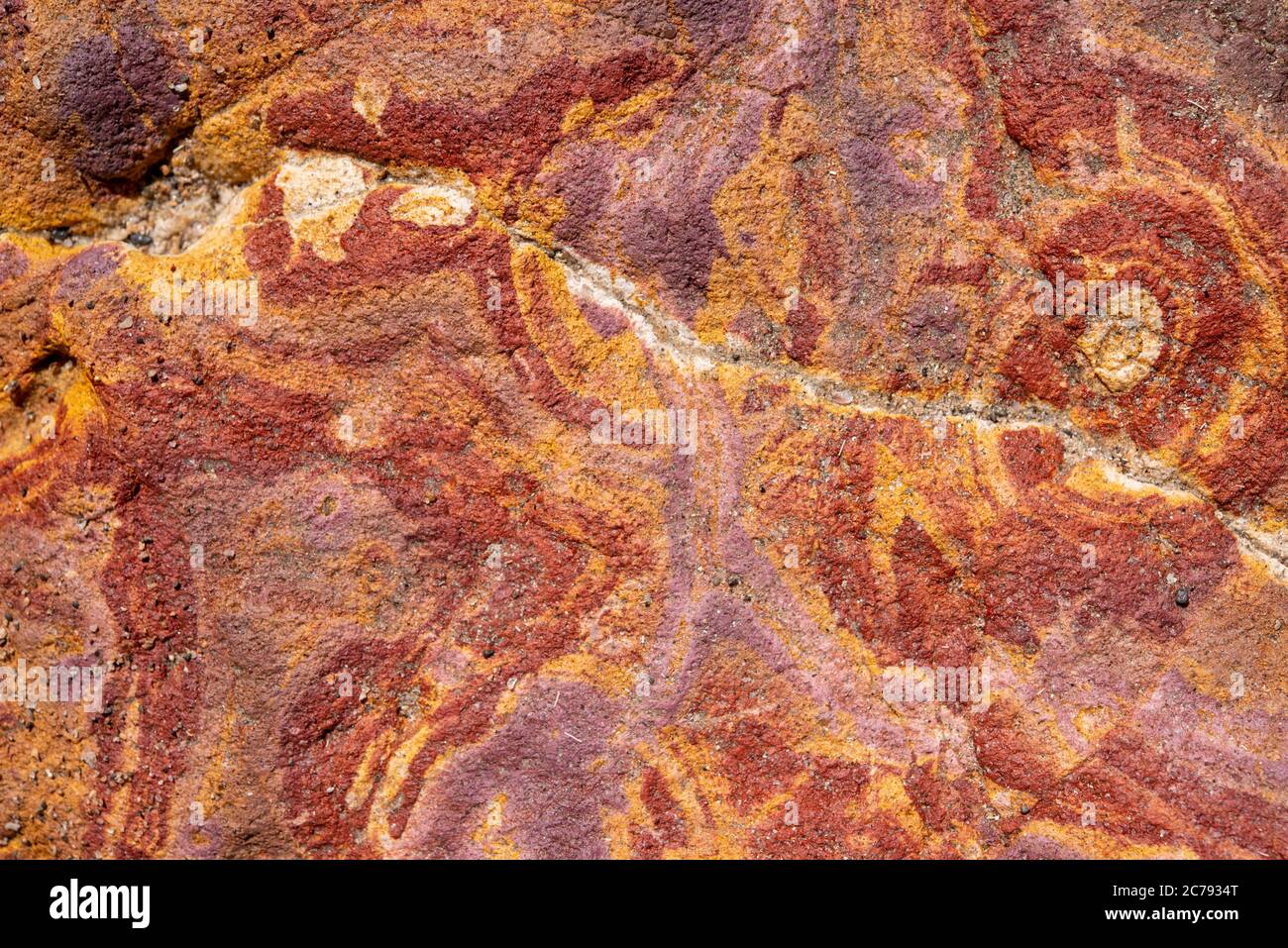 Colorful sand and sedimentary rocks, creating abstract patterns on the ...