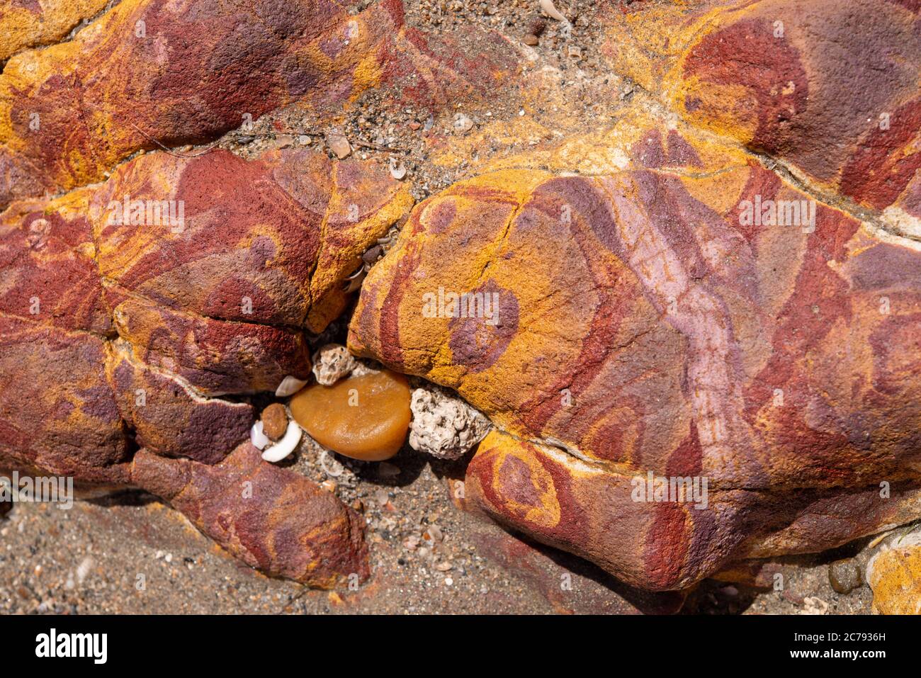 Colorful sand and sedimentary rocks, creating abstract patterns on the ...