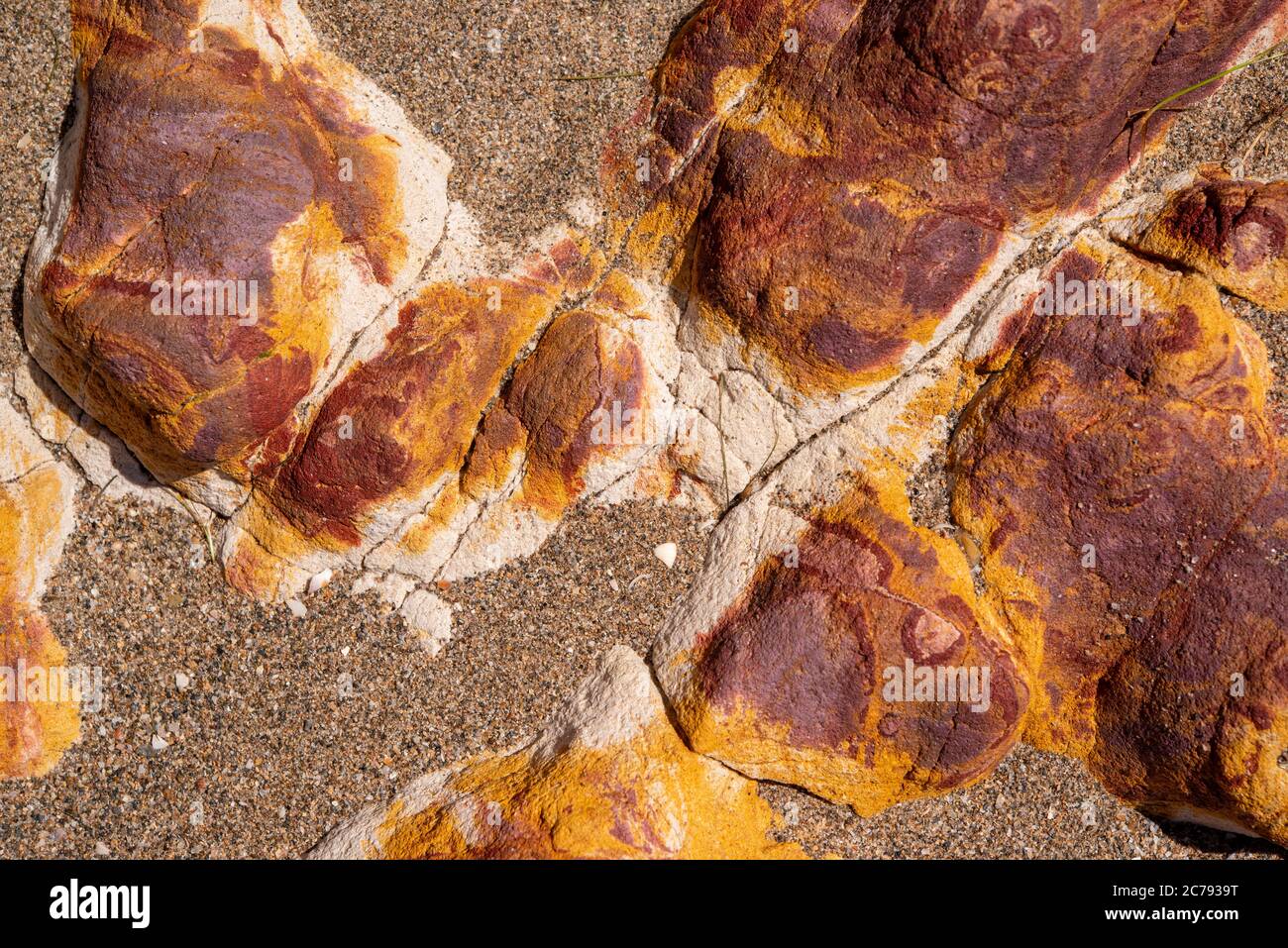Colorful sand and sedimentary rocks, creating abstract patterns on the ...