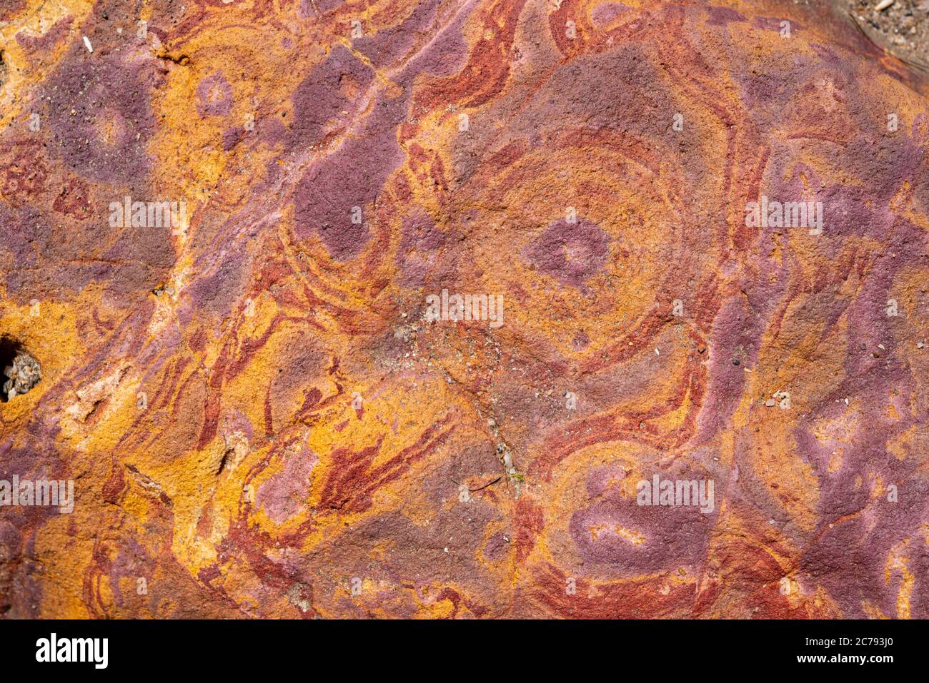 Colorful sand and sedimentary rocks, creating abstract patterns on the ...