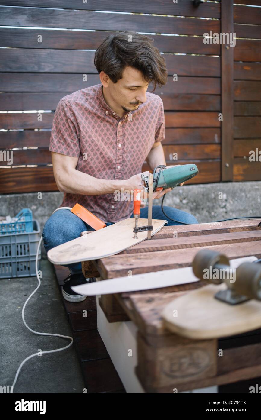 Focused man using electric saw in workshop Stock Photo - Alamy