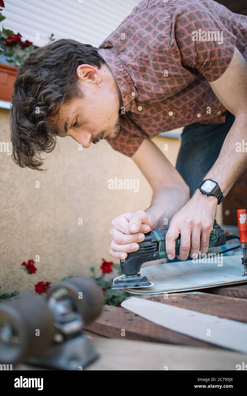 Portrait of young man using power sander outdoor Stock Photo - Alamy