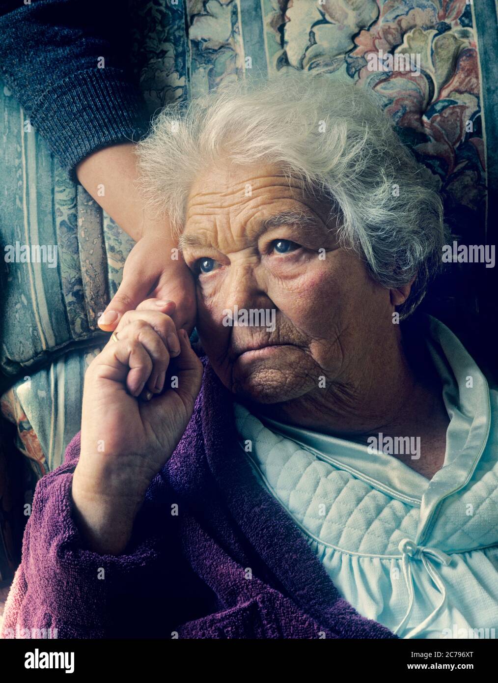 Holds comforting hand of carer in natural light interior hi-res stock ...