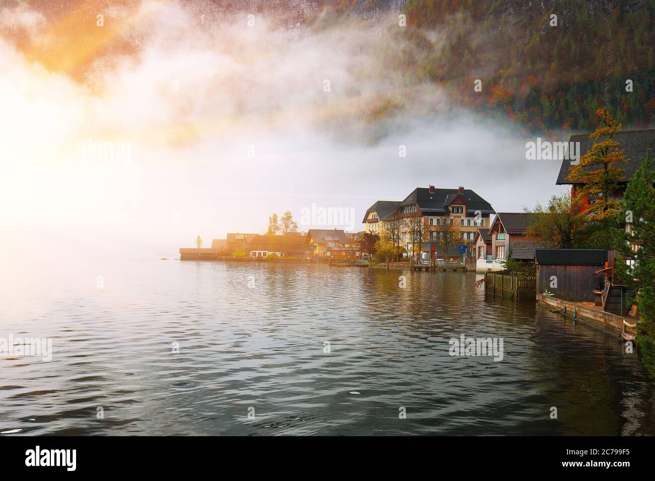 Scenic view of famous Hallstatt mountain village with Hallstatter lake. Foggy autumn sunrise on ...