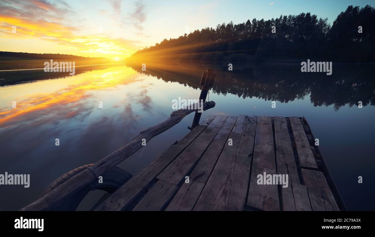 Wooden dock, pier, on a lake in the evening. Dramatic sunset Stock ...