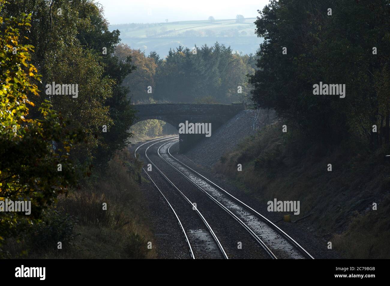 Empty rail track passing beneath a bridge in the English countryside ...