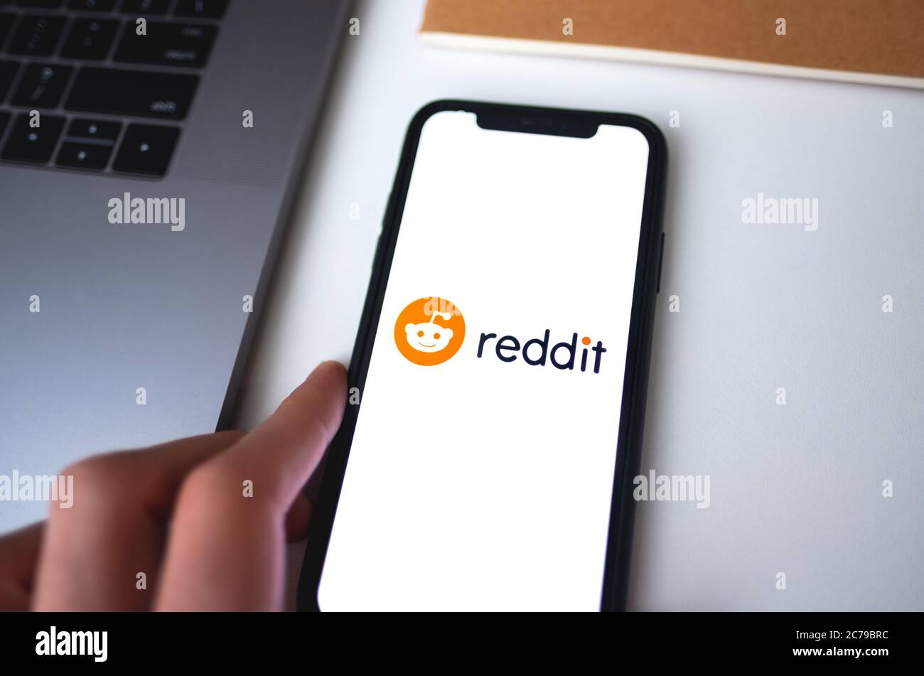 Reddit logo on the smartphone screen in hand Stock Photo - Alamy