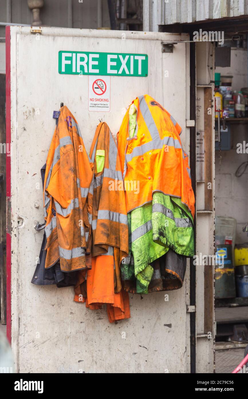 Oil stained high-visibility coats hung at the workshop entrance to the ... Oil stained high-visibility coats hung at the workshop entrance to the ...