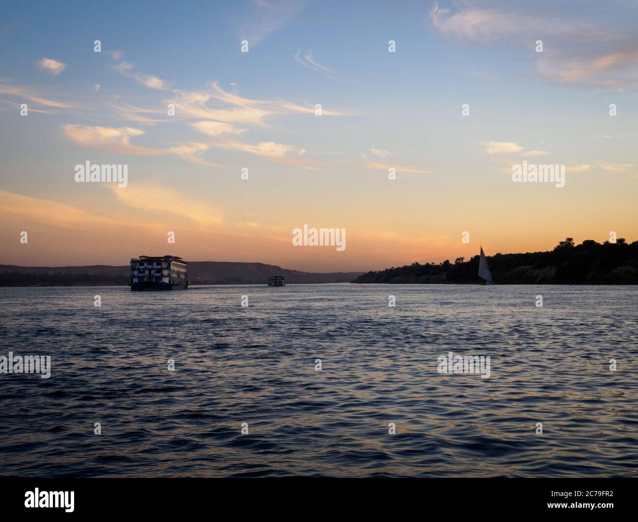 sun is setting on river nile with boats sailing Stock Photo - Alamy