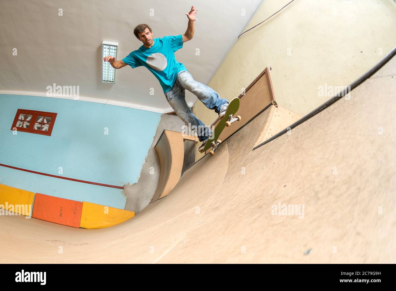 Skateboarder performing a trick on mini ramp at indoor skate park Stock ...