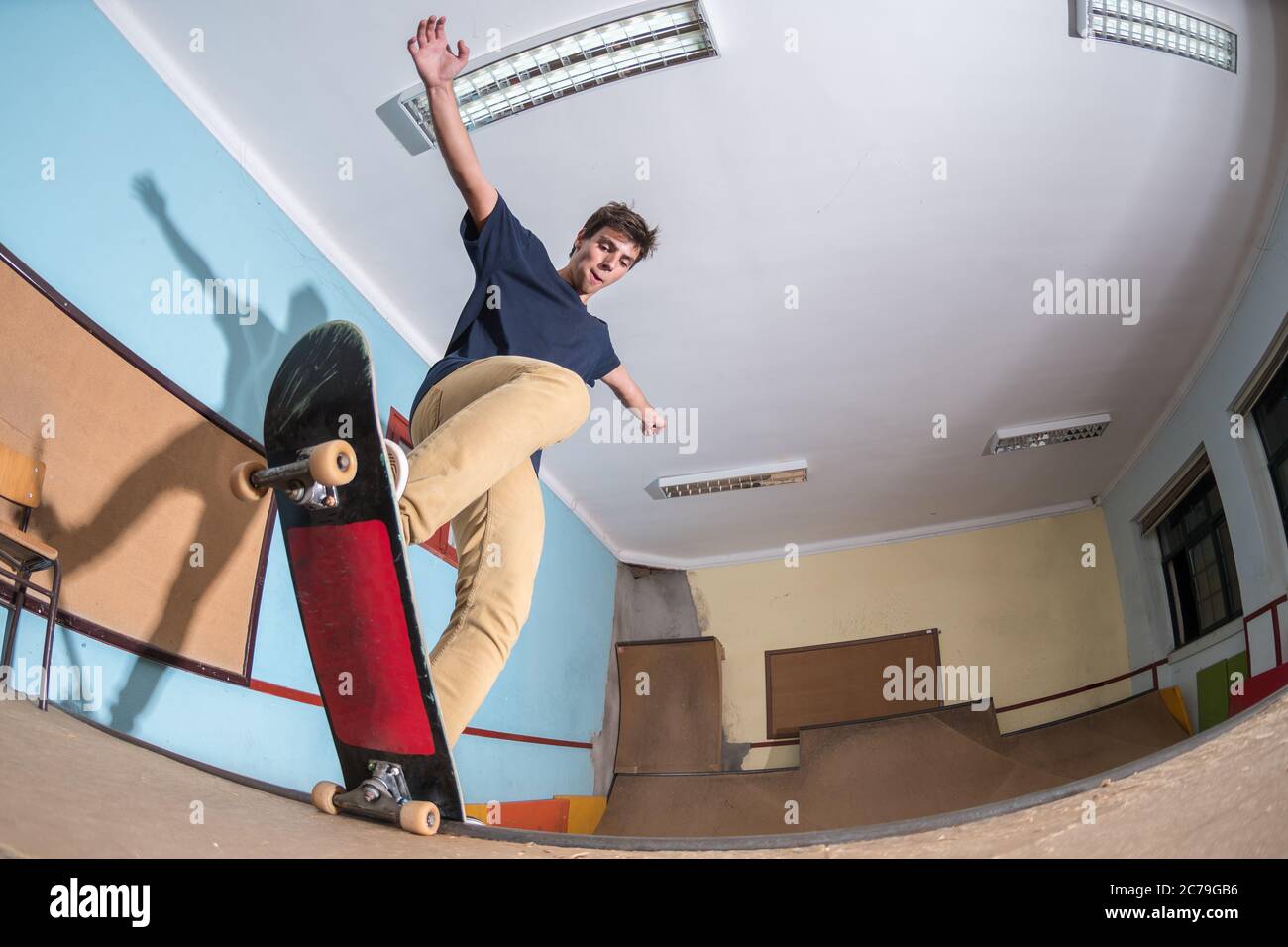Skateboarder performing a trick on mini ramp at indoor skate park Stock ...