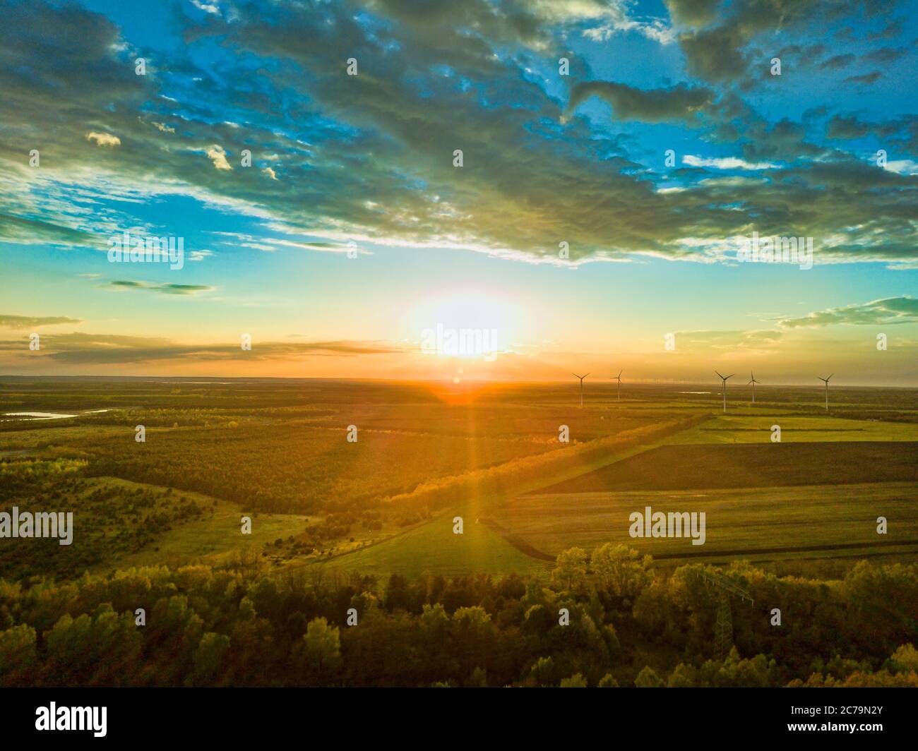 Landscape the wind wheels with a bright undergoing sun in the horizon ...