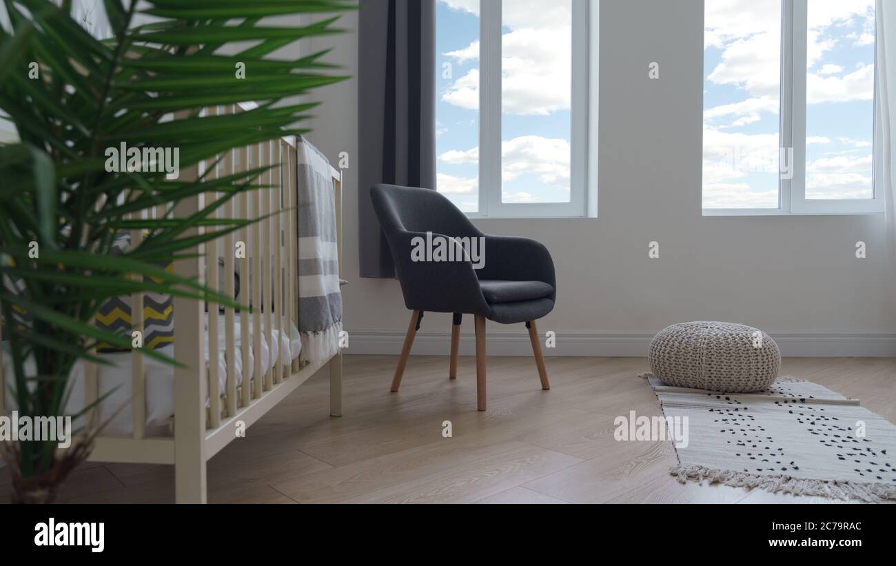 Modern gray chair and stool puff on woven rug in bedroom Stock Photo ...