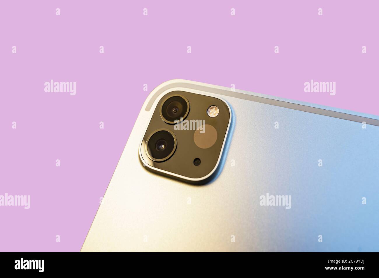 Close-up of tablet computer camera system on a pink background. Light ...