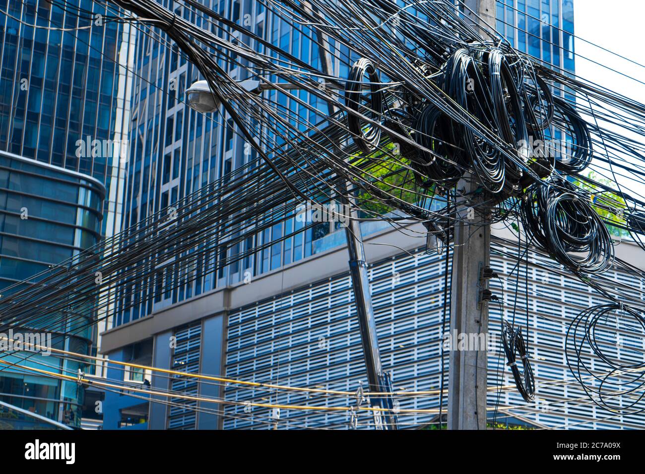 Post with electrical wiring in Thailand. Coils of wires Stock Photo - Alamy