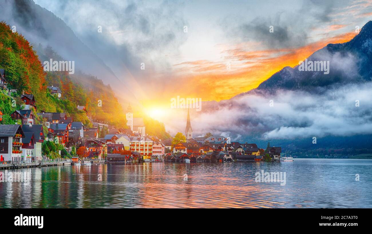 Scenic view of famous Hallstatt mountain village with Hallstatter lake. Foggy autumn sunrise on ...