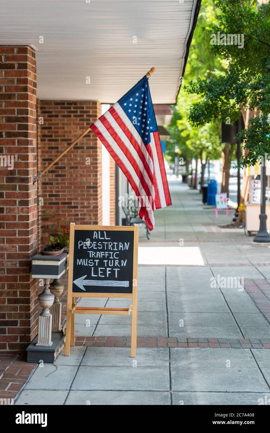 American flag hanging on a storefront in a small town. Chalkboard ...
