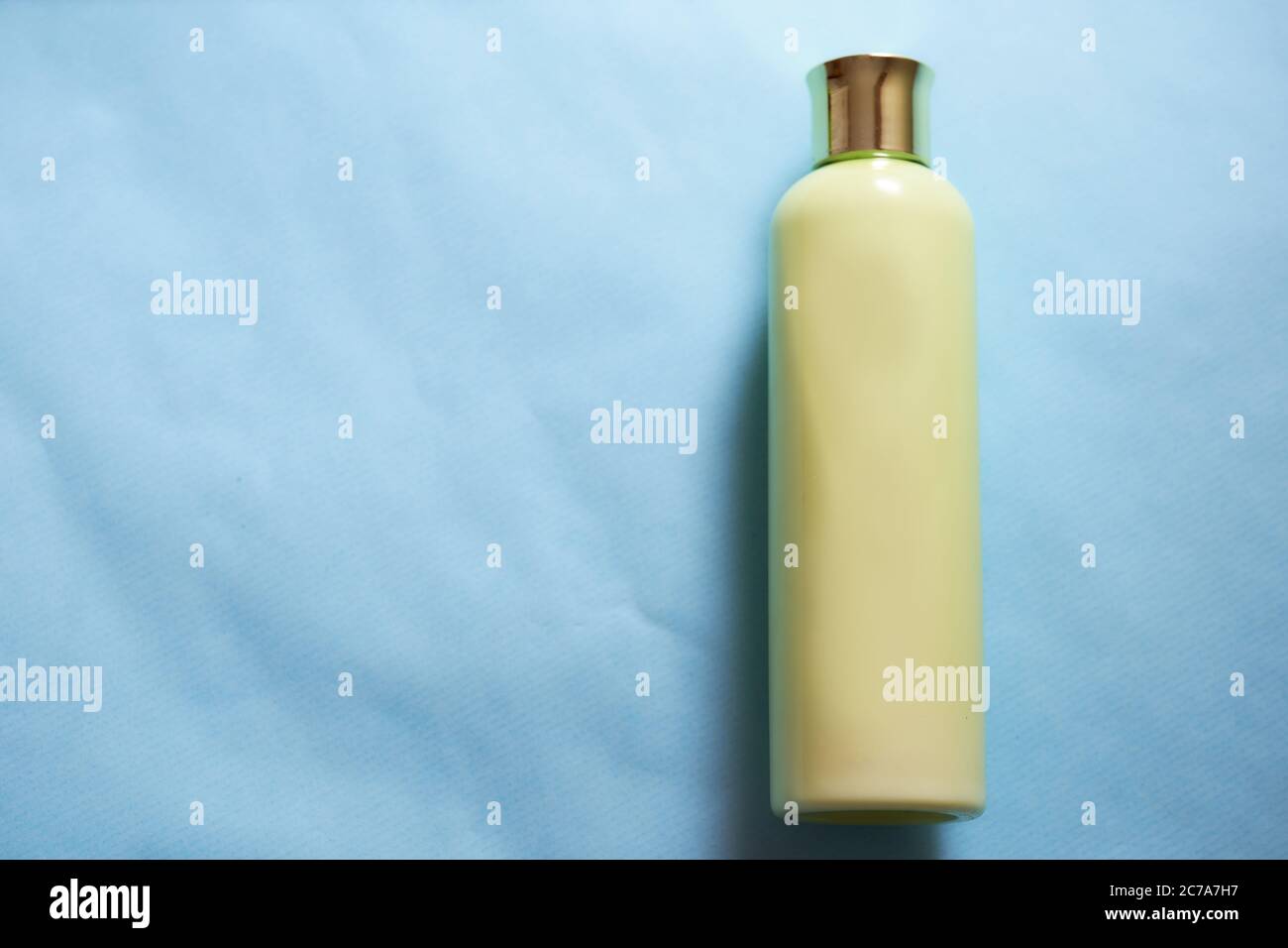 Yellow vial for cosmetics on a blue background. With copy space Stock ...