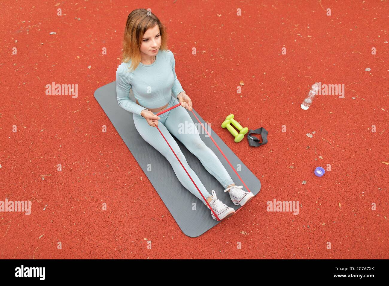 The concept of sports training outdoors. Pretty blond fit girl does ...