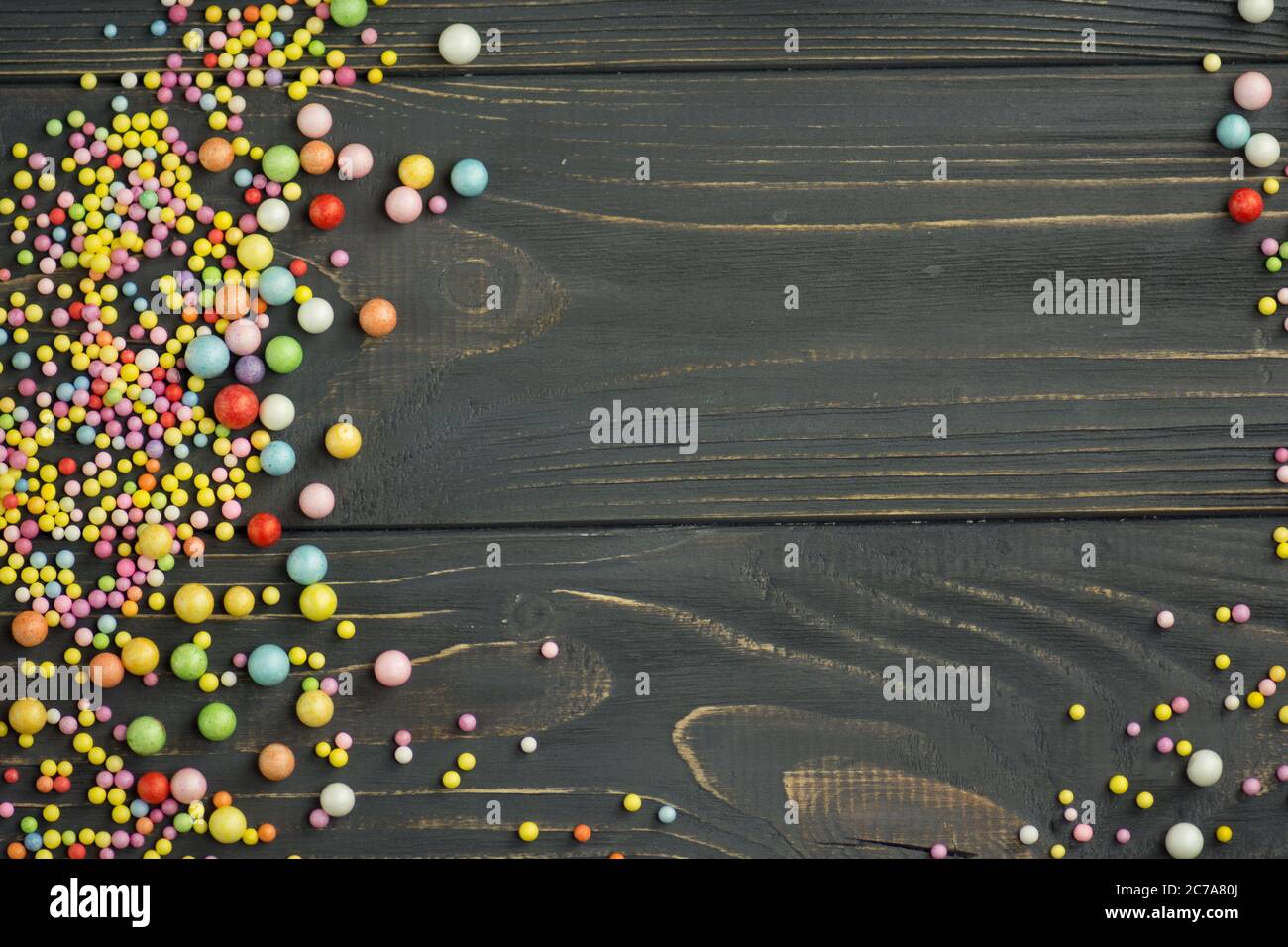 Colorful foam ball texture. Colorful polystyrene foam on a black wooden ...