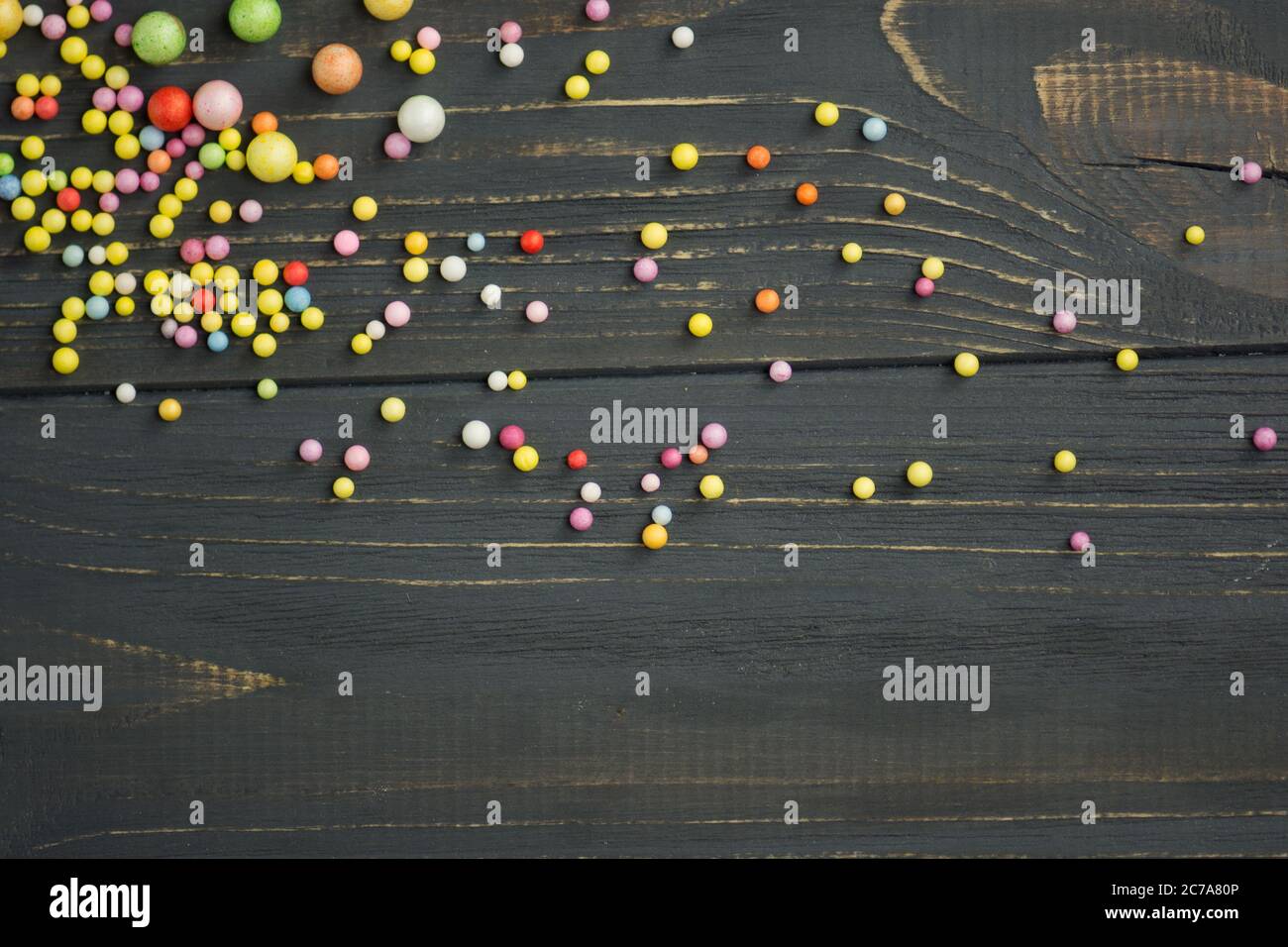 Colorful foam ball texture. Colorful polystyrene foam on a black wooden ...