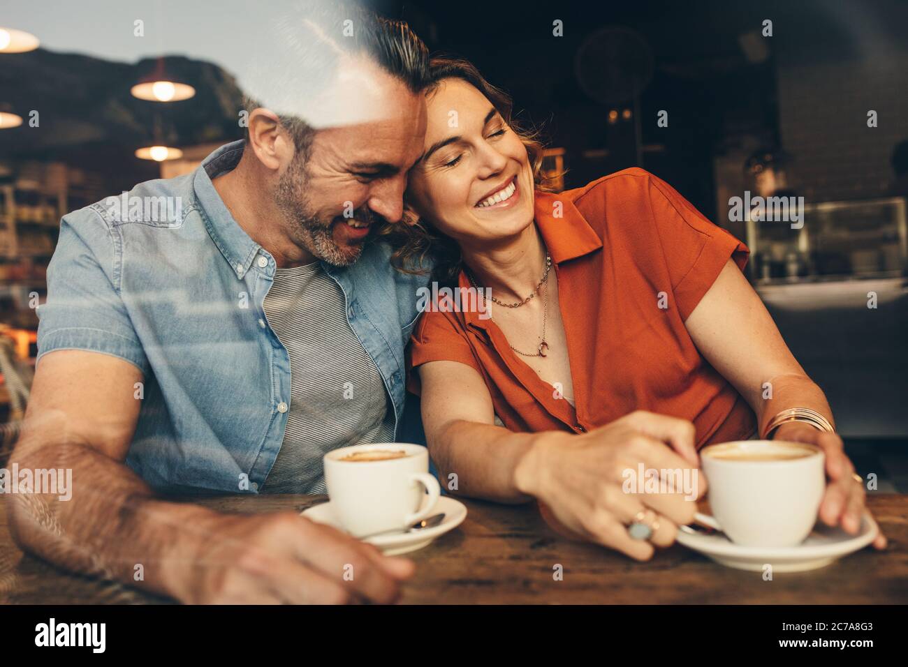 Happy couple sitting together at a coffee shop and relaxing. Couple in ...