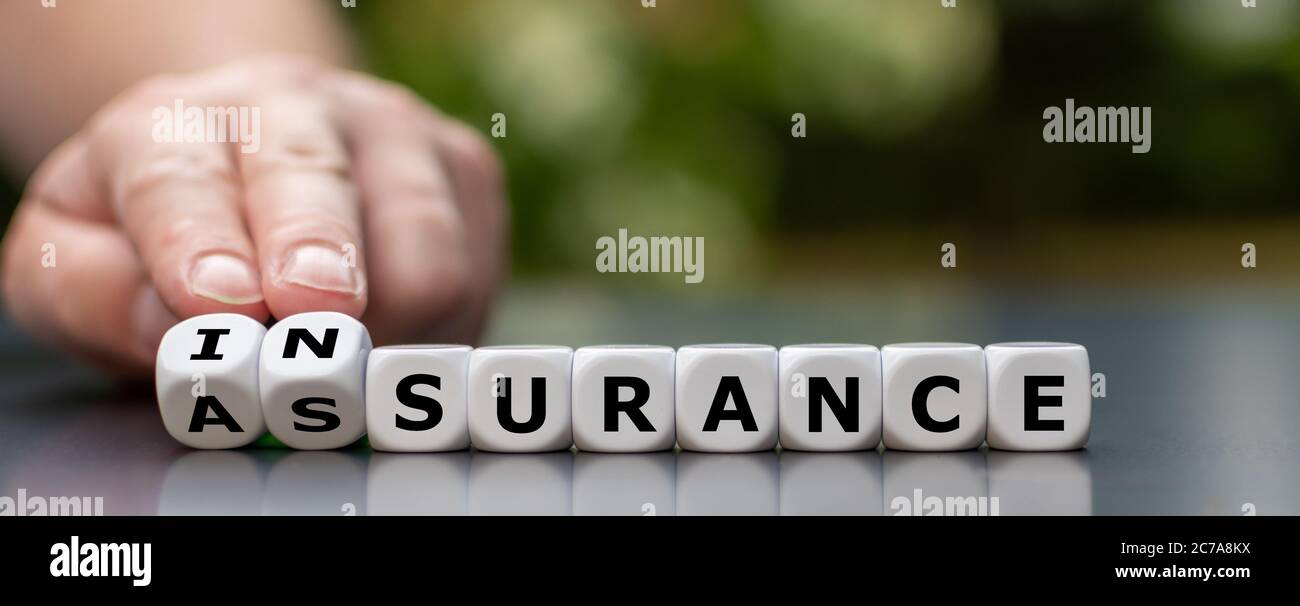 Hand turns dice and changes the word assurance to insurance Stock Photo ...