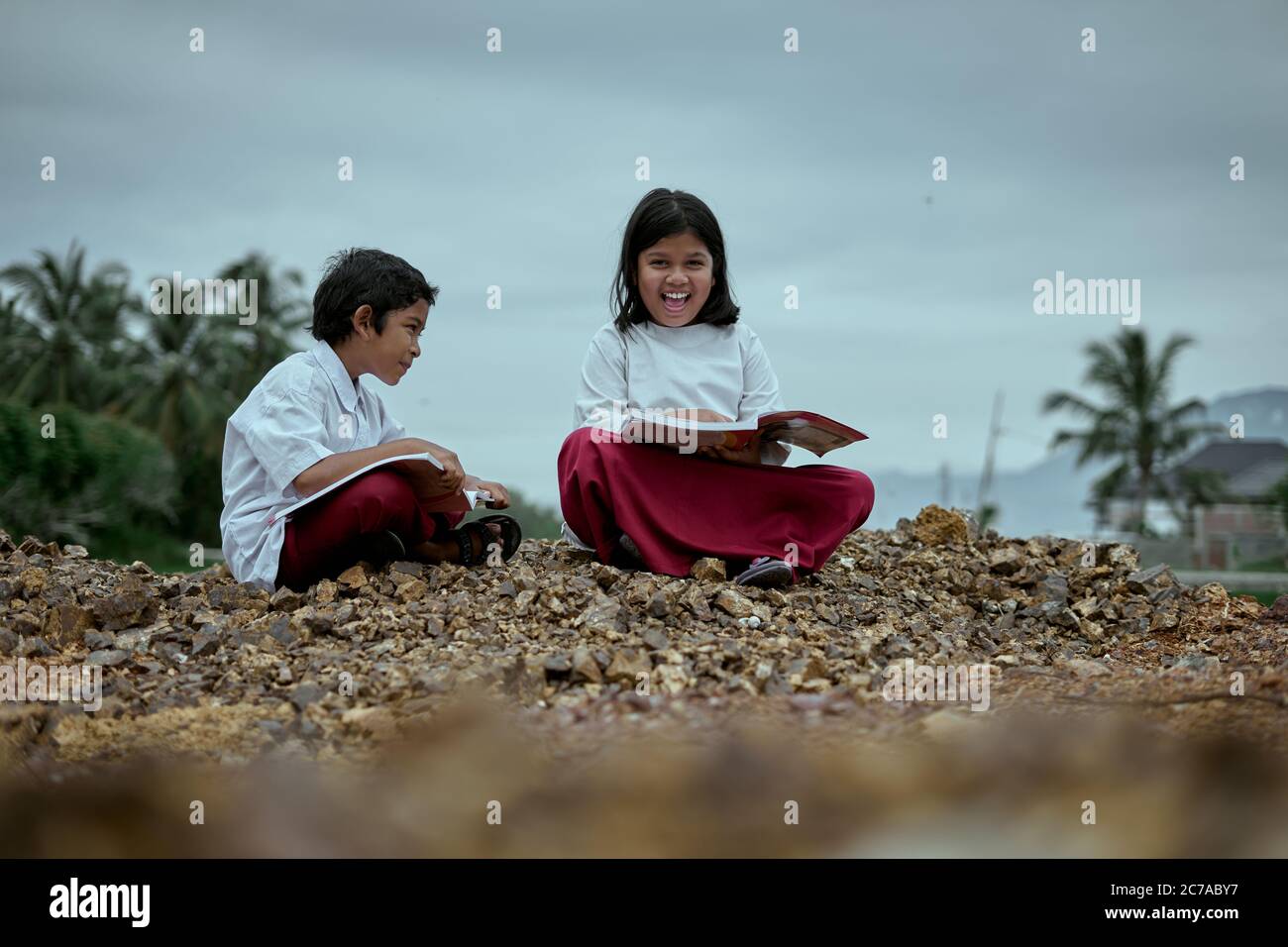 Two elementary school students studying together at public park Stock ...