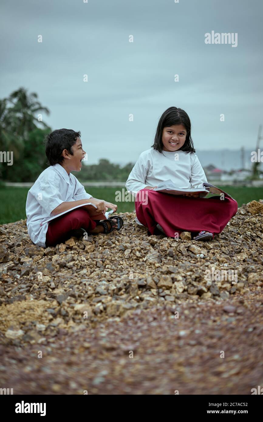 Two elementary school students studying together at public park Stock ...