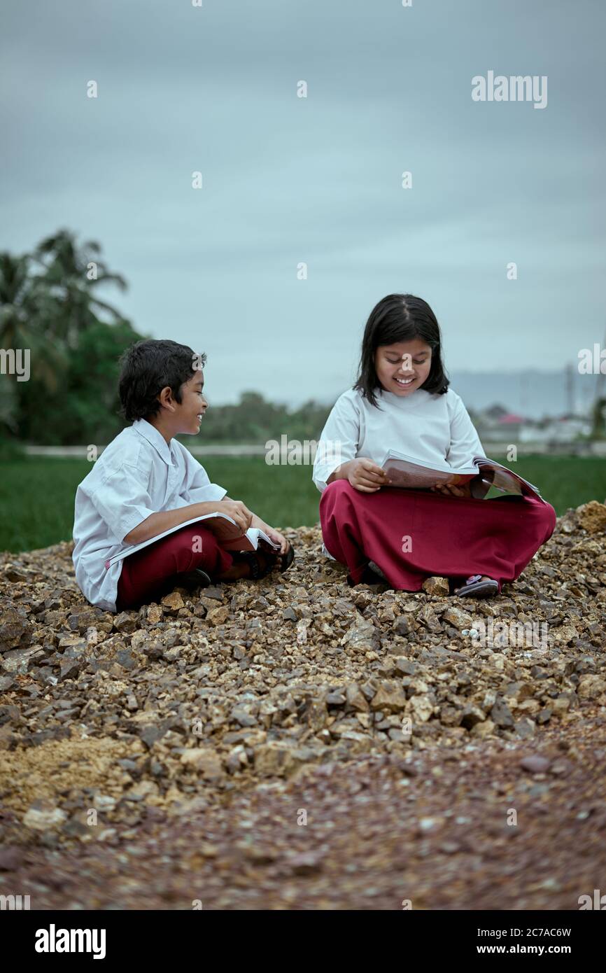 Two elementary school students studying together at public park Stock ...