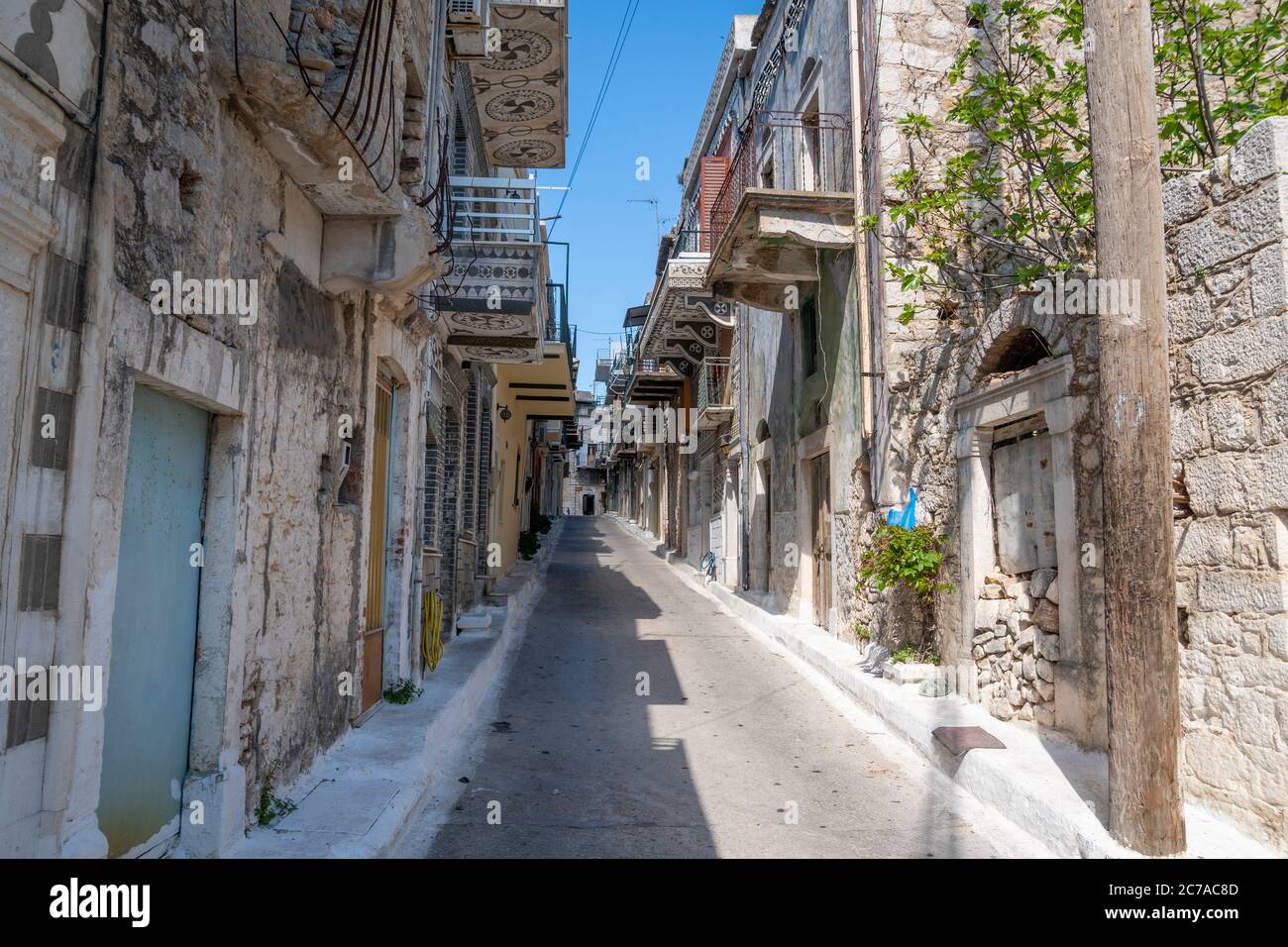 A narrow alley between stone houses with traditional geometric patterns ...